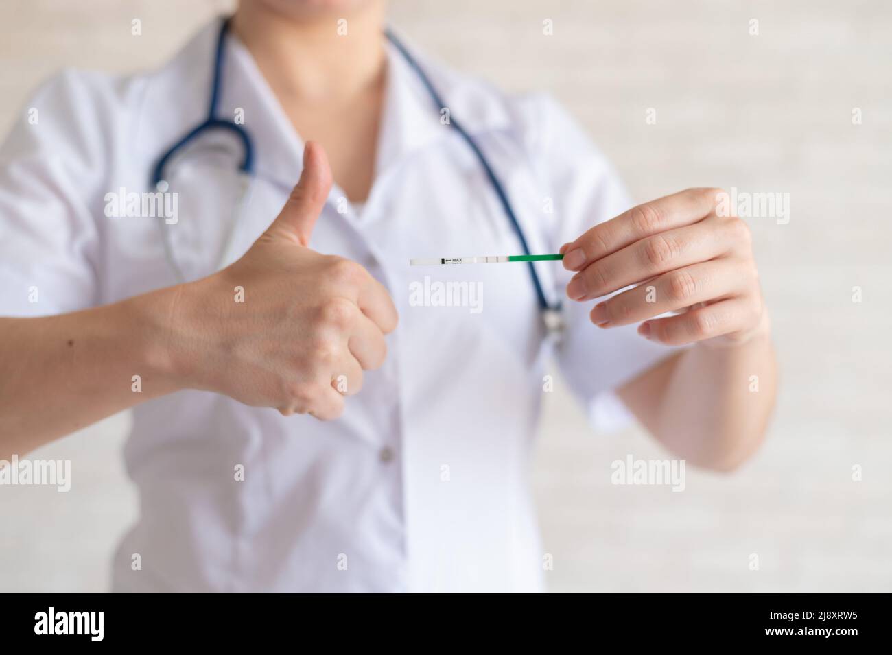 A faceless doctor in a medical coat and with a stethoscope holds a ...