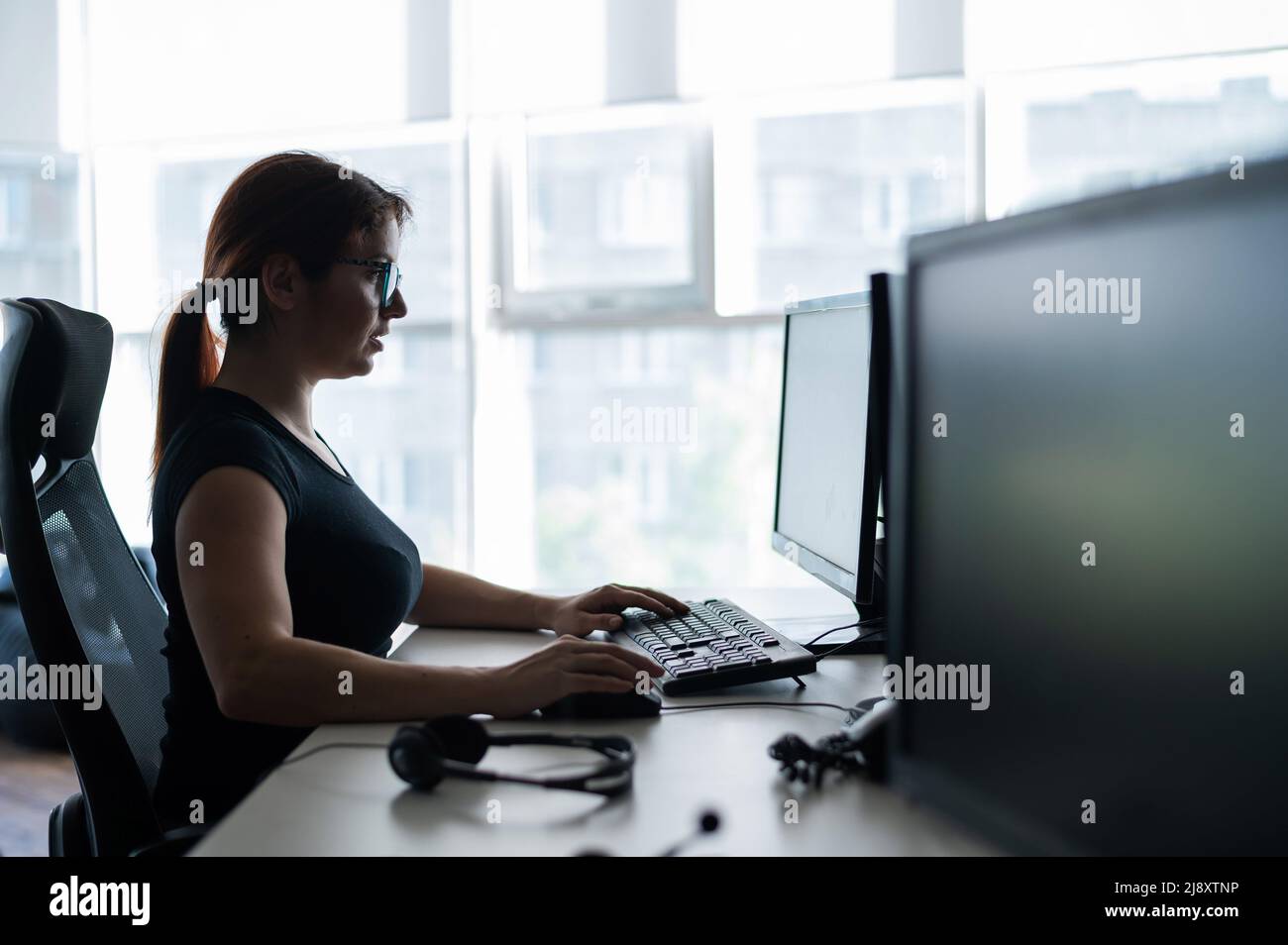 Silhouette of a caucasian business woman typing at a computer. Female ...