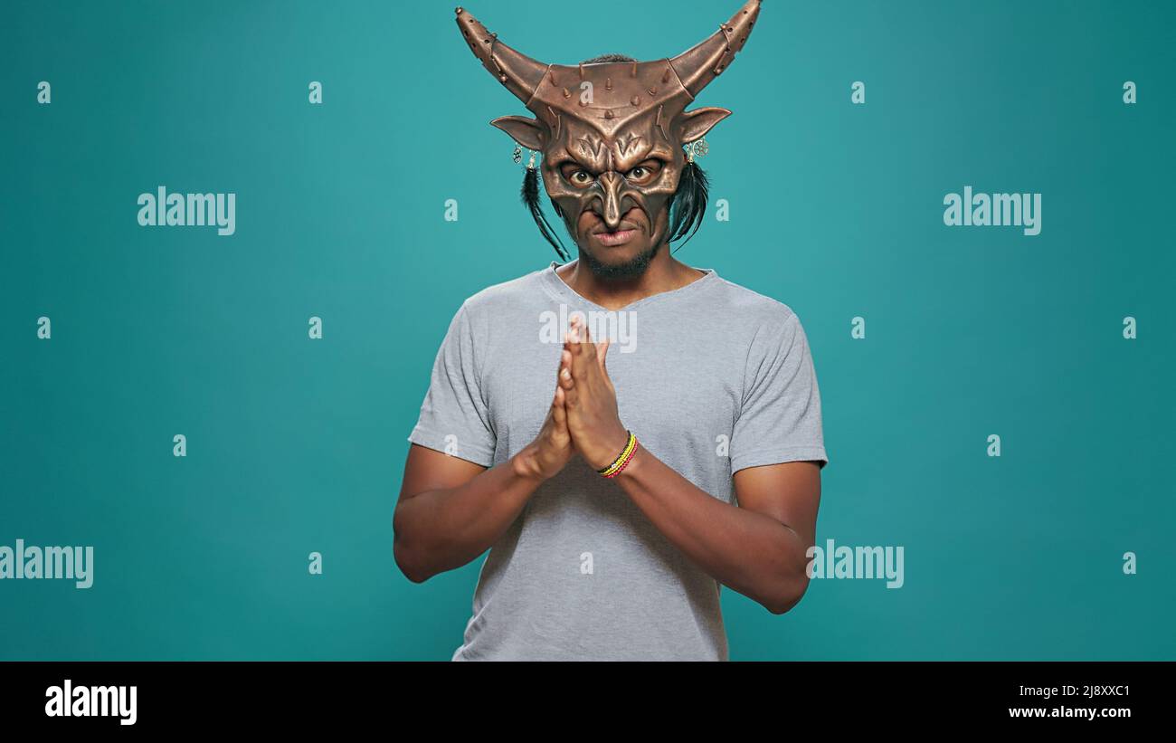 Young man wearing ancient tribal mask with sacral pattern and design ...