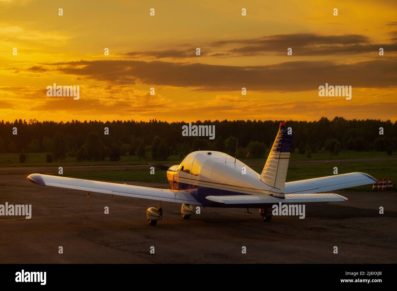 Rear view of a parked small plane on a sunset background. Silhouette of ...