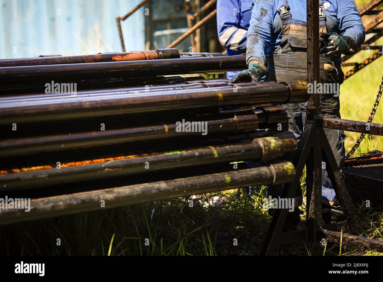 Oil and gas industry worker operates oil rig drill pipes on an oil well ...