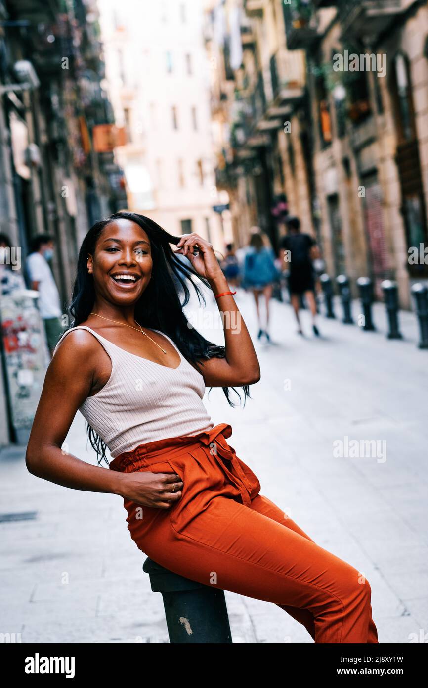 Smiling African American woman looking at camera while posing outdoors ...