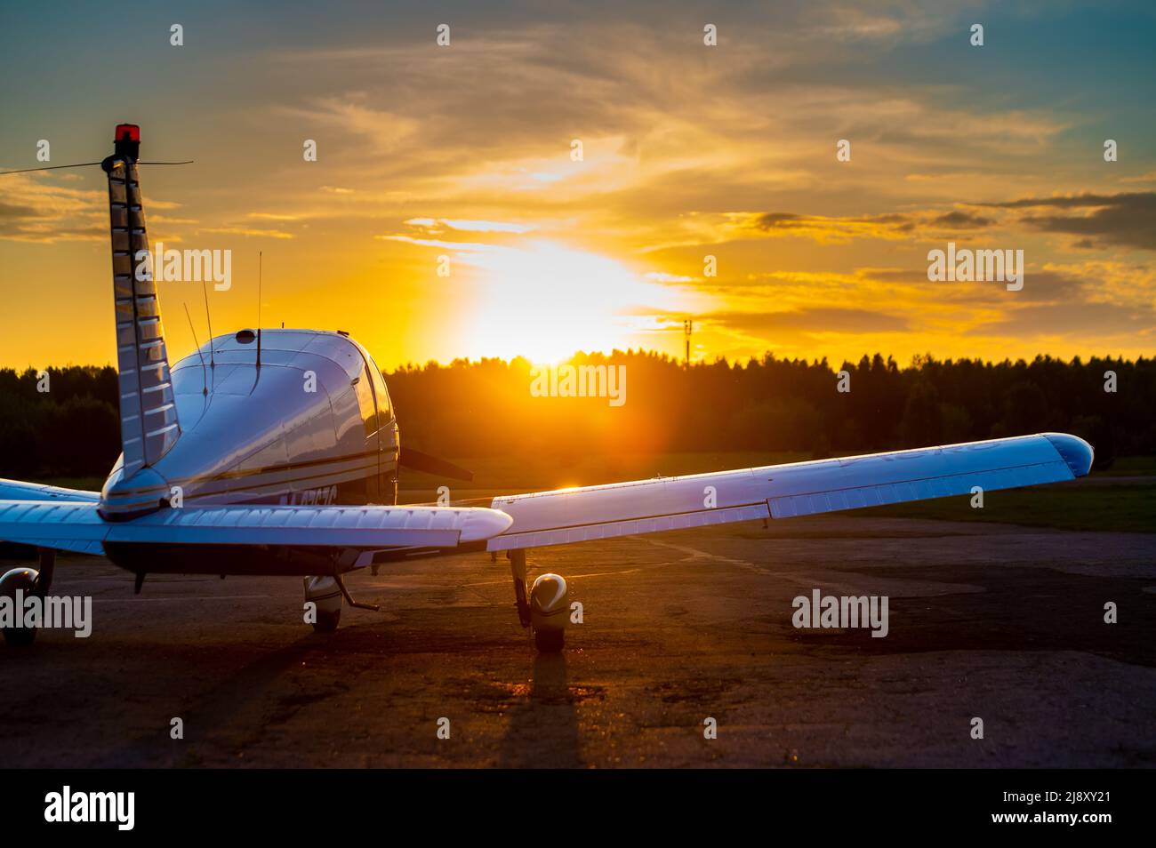 Rear view of a parked small plane on a sunset background. Silhouette of ...