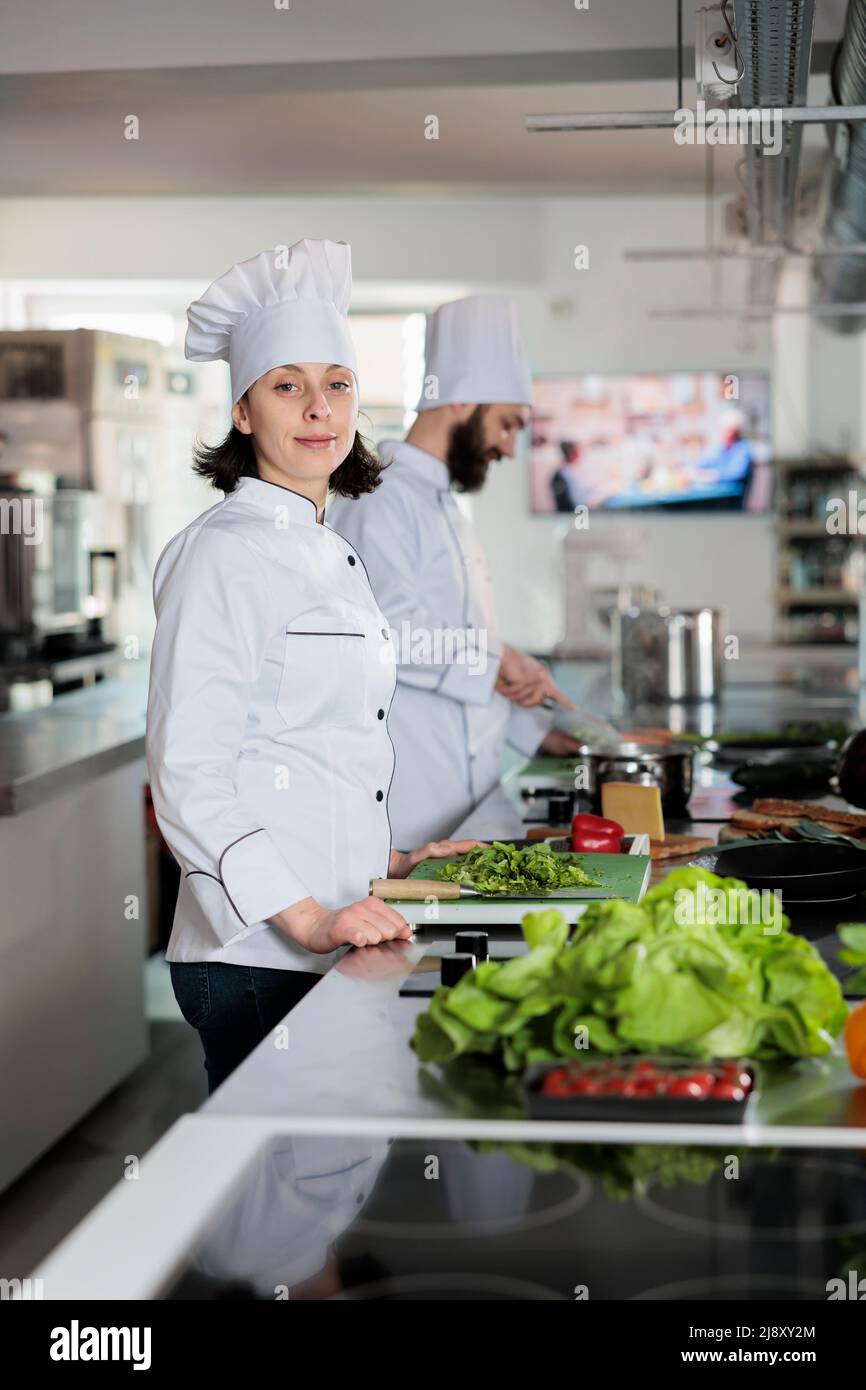 Portrait of beautiful happy sous chef standing in restaurant ...