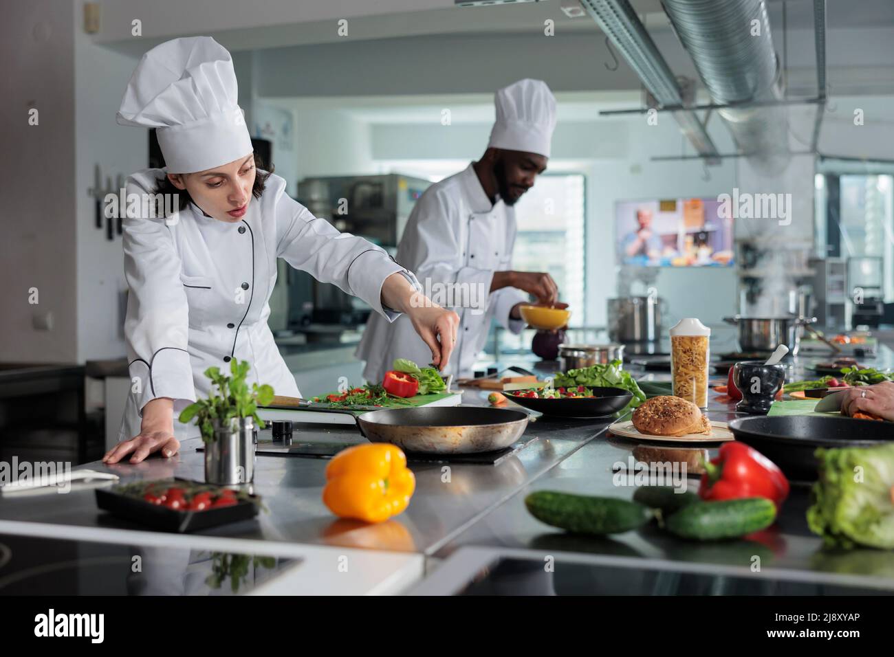 Head chef cooking food for dinner service while adding ingredients to ...