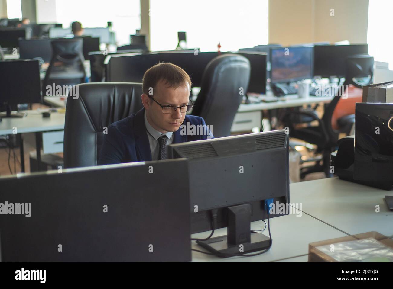Happy male employee at the workplace in the office Open Space. Friendly ...