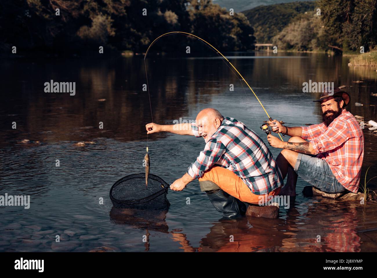 Catching fish. Portrait of cheerful senior man fishing. Grandfather and ...