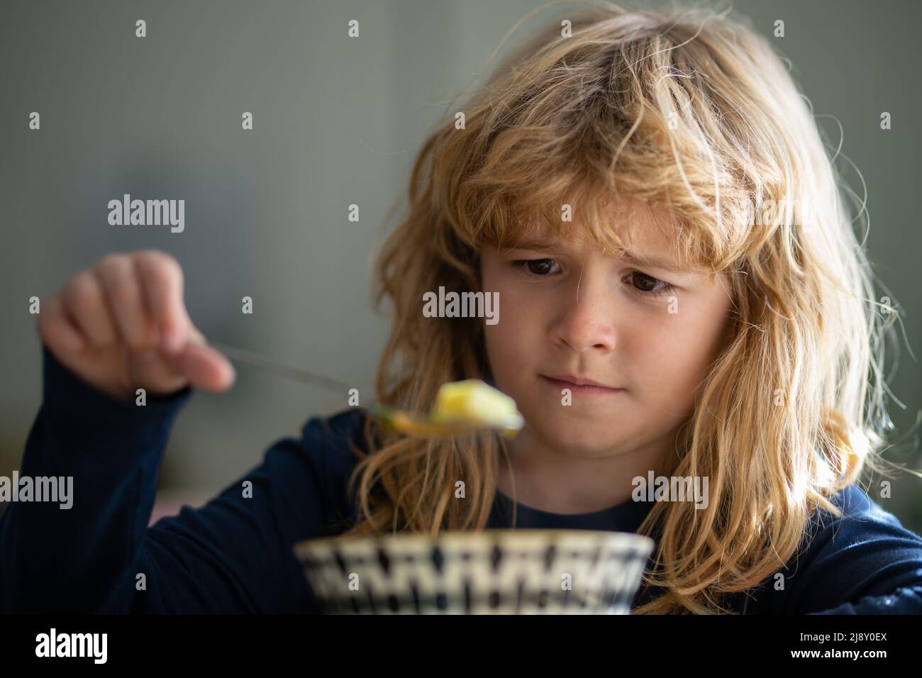 Cute child eating breakfast at home. Sad boy eating healthy chicken ...