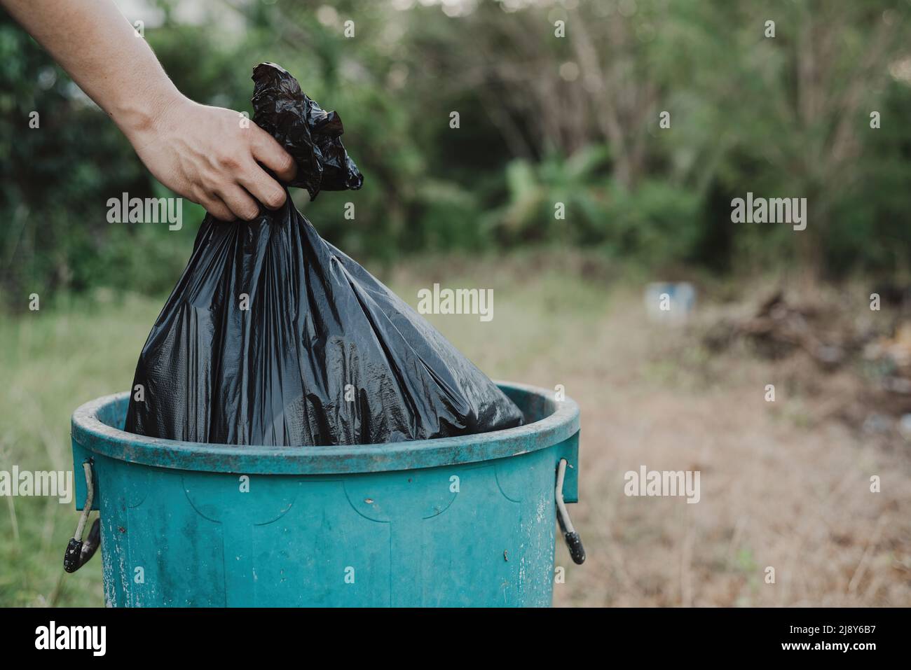 hand holding a garbage bag and is dropping into the trash Stock Photo ...