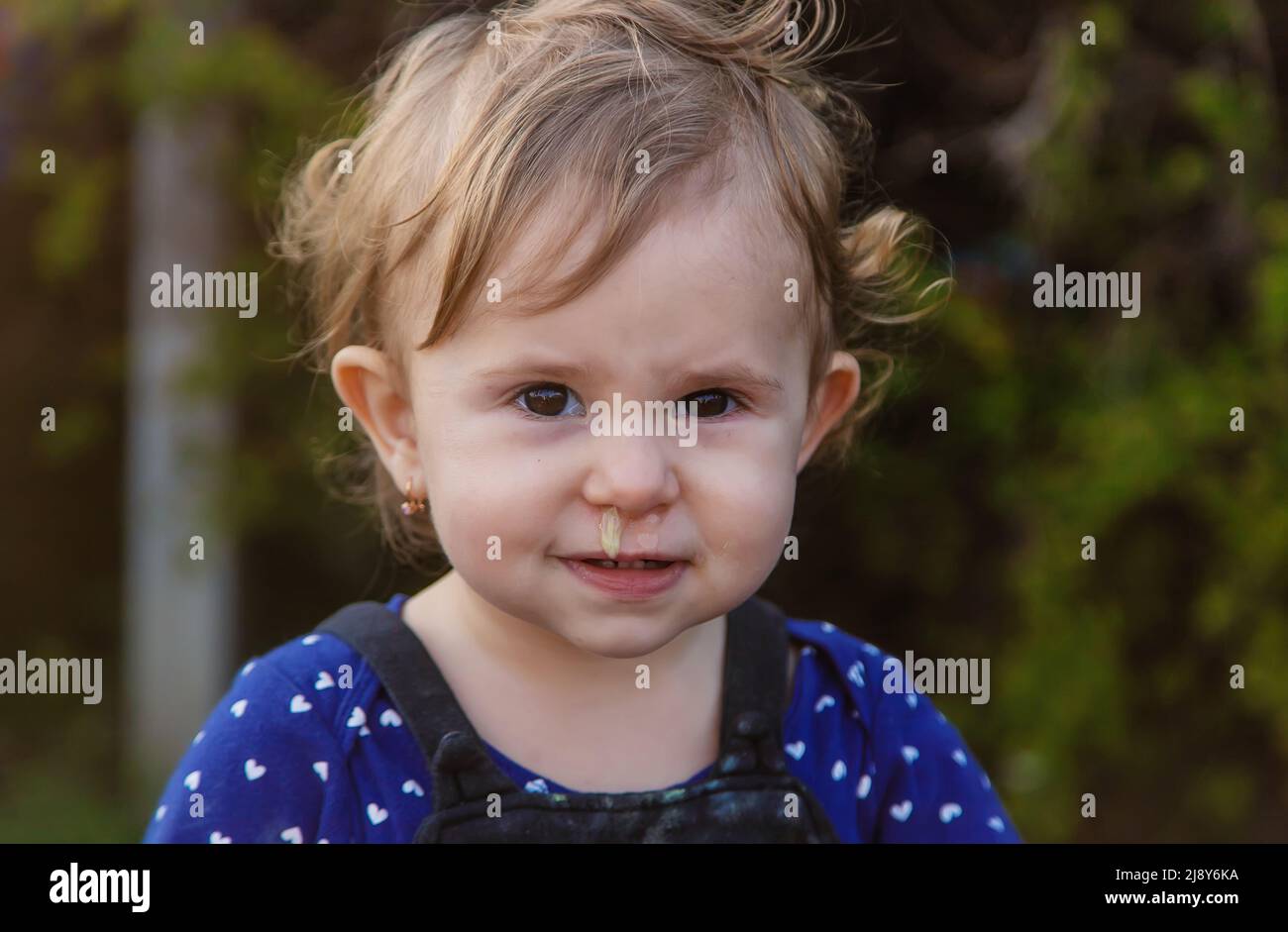Baby plays snot in the street with a cold nose. Selective focus Stock ...