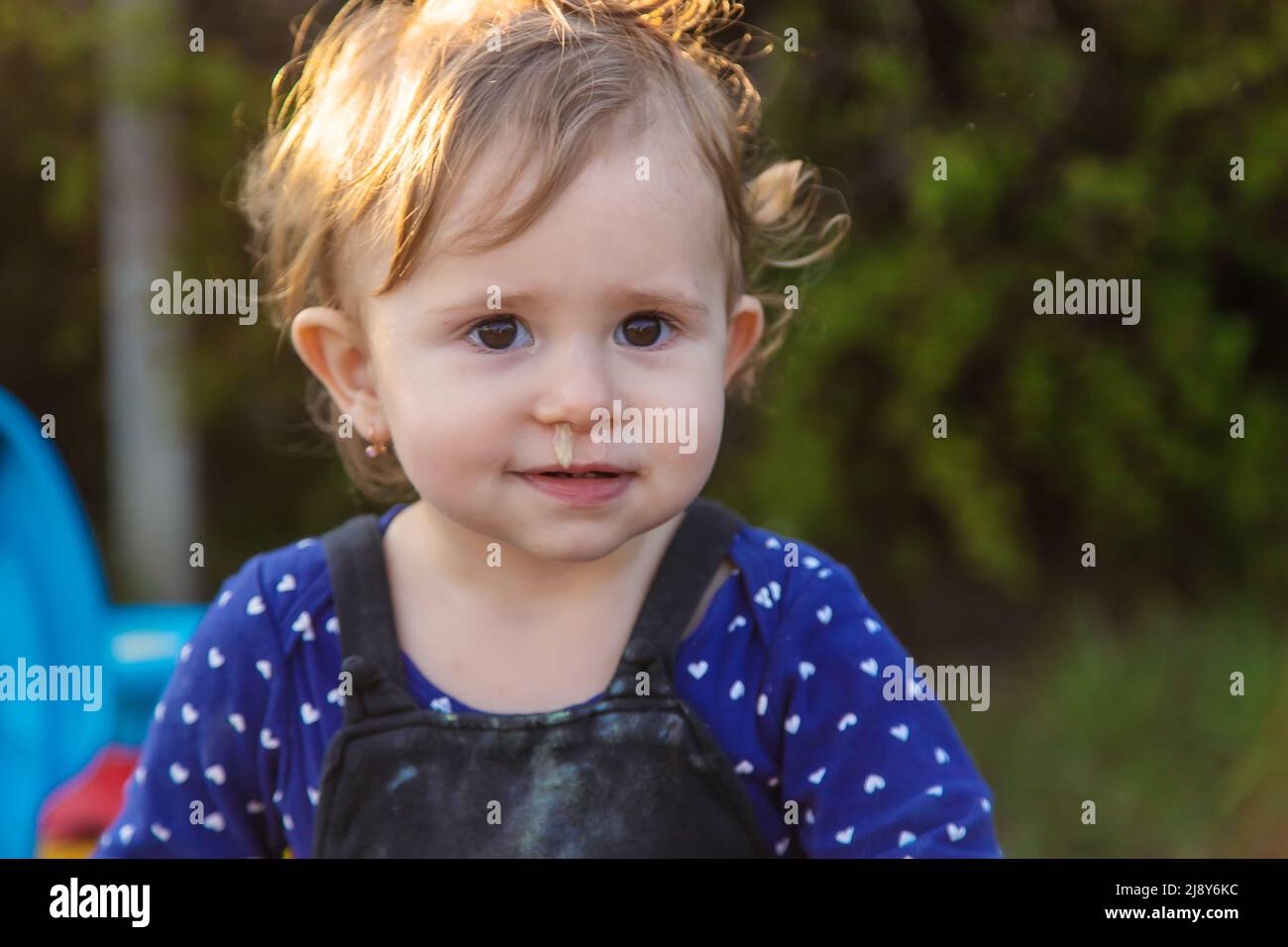 Baby plays snot in the street with a cold nose. Selective focus Stock ...