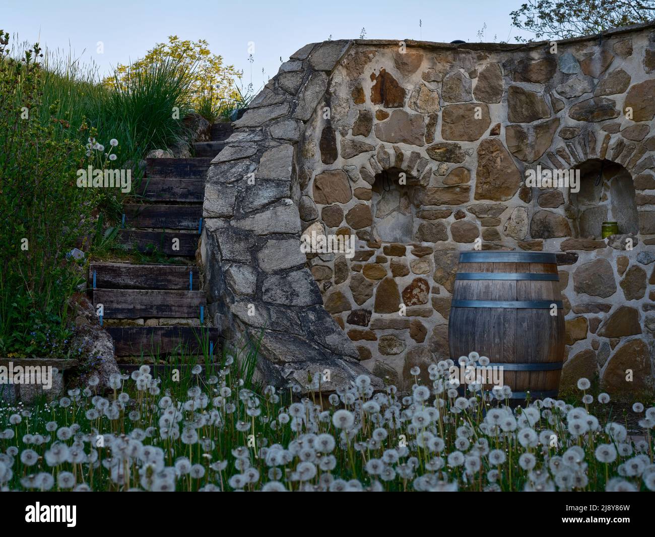 Still life with a wooden barrel, a stone wall, wooden stairs and full ...