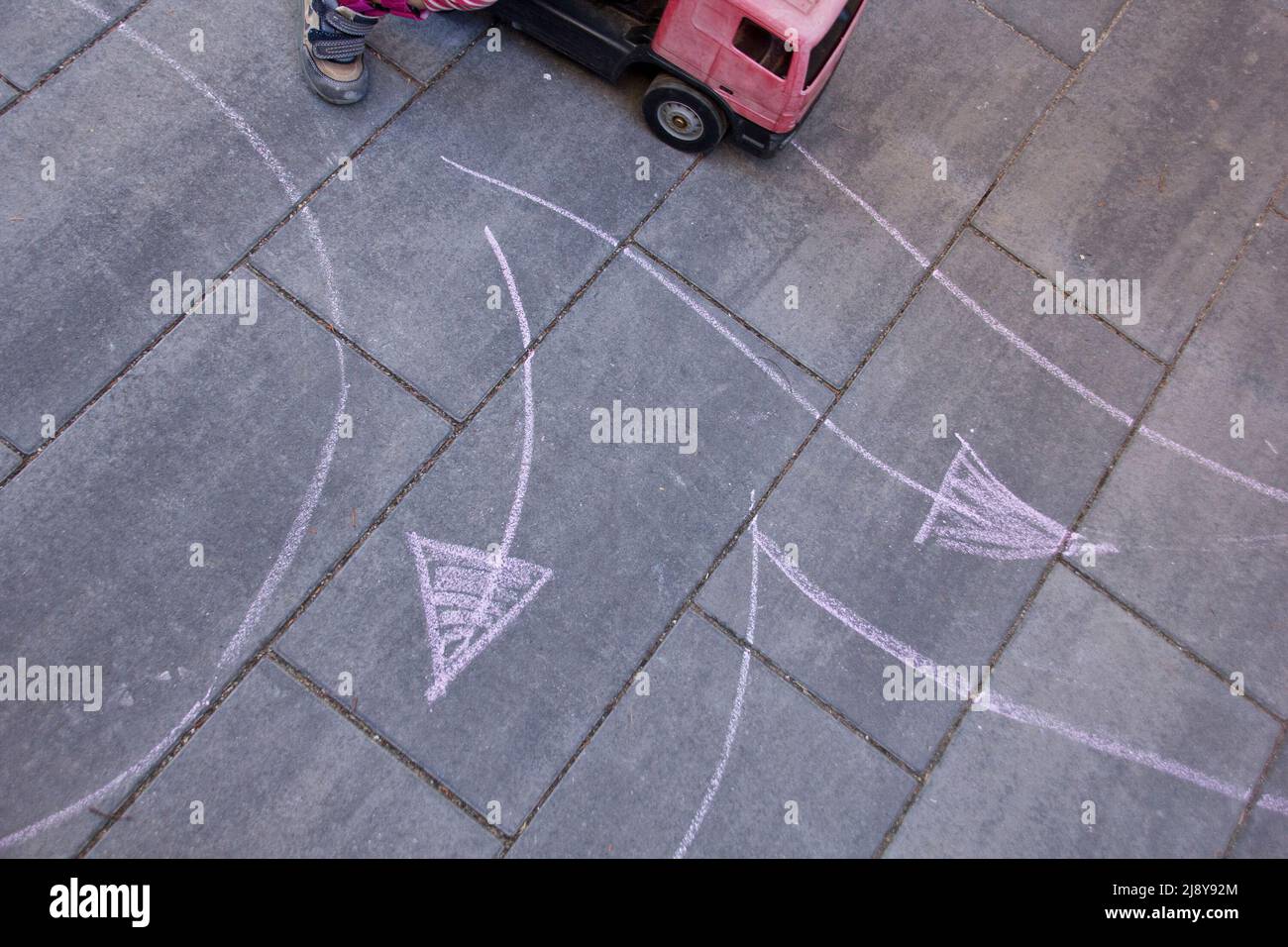 Little child on toy truck has to decide which direction he will drive ...