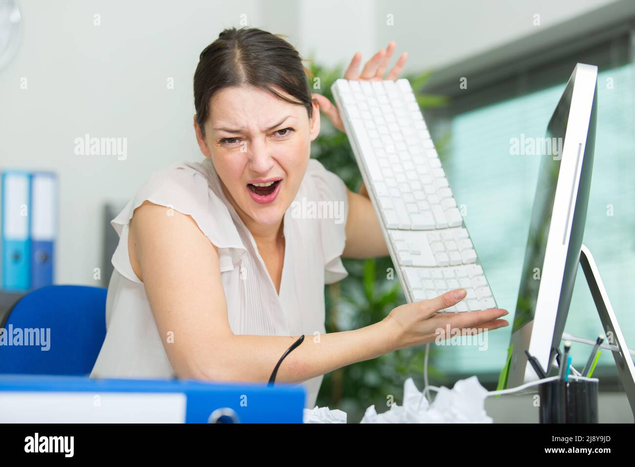 annoyed and angry woman working on her office desk Stock Photo - Alamy