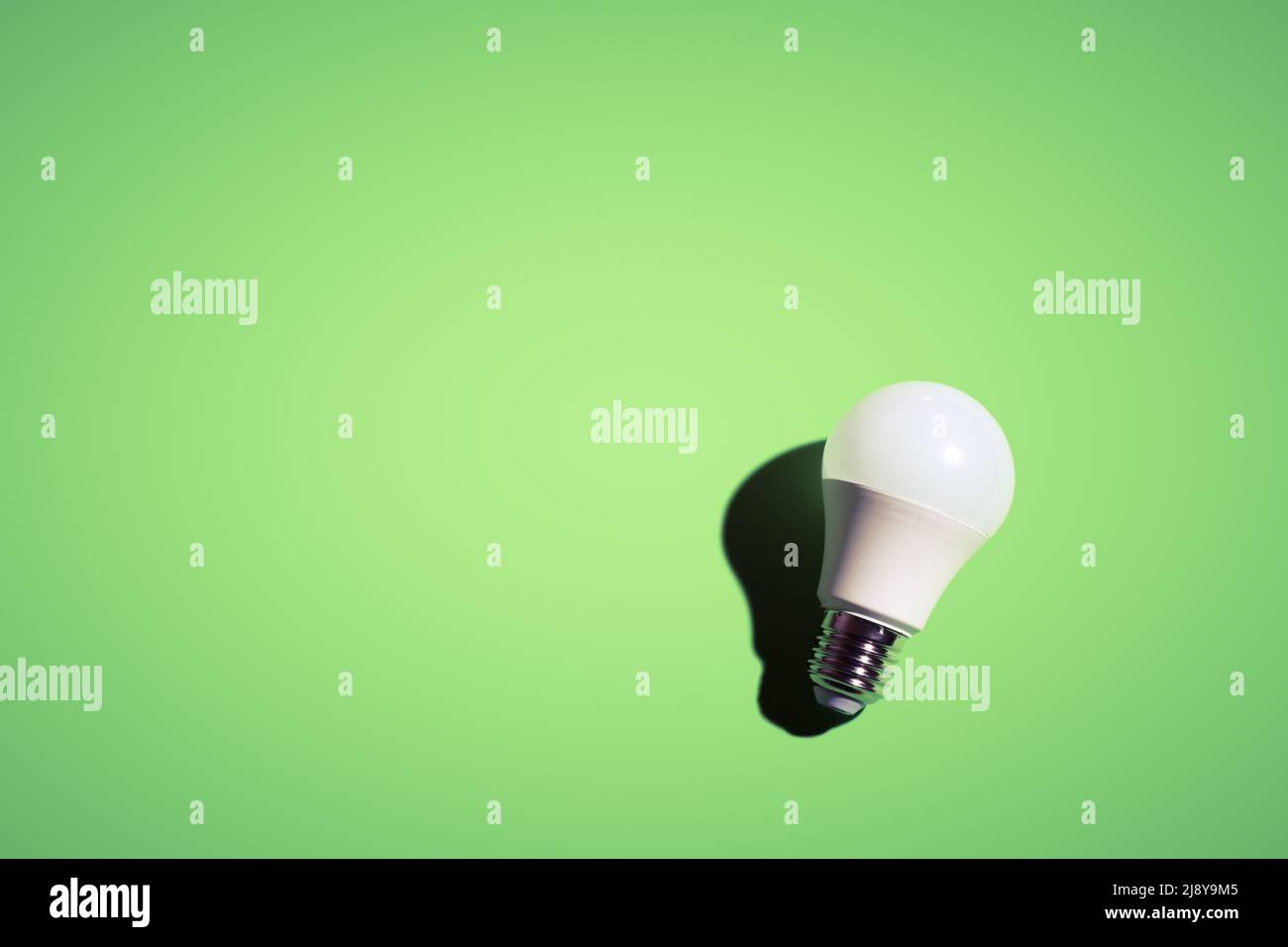 White lightbulb on green background under the bright light with black ...