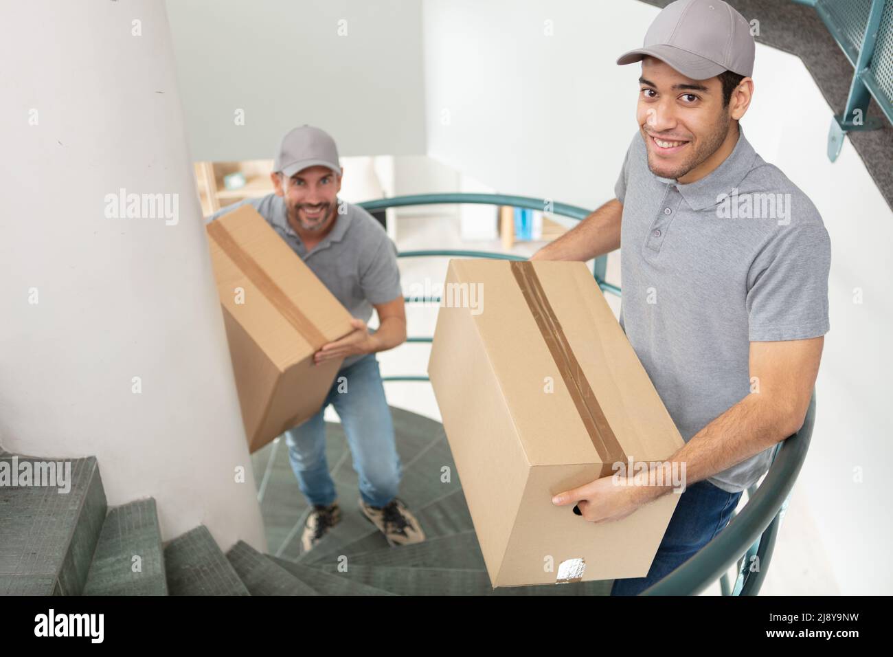 2 men holding carton box in the stairs Stock Photo - Alamy
