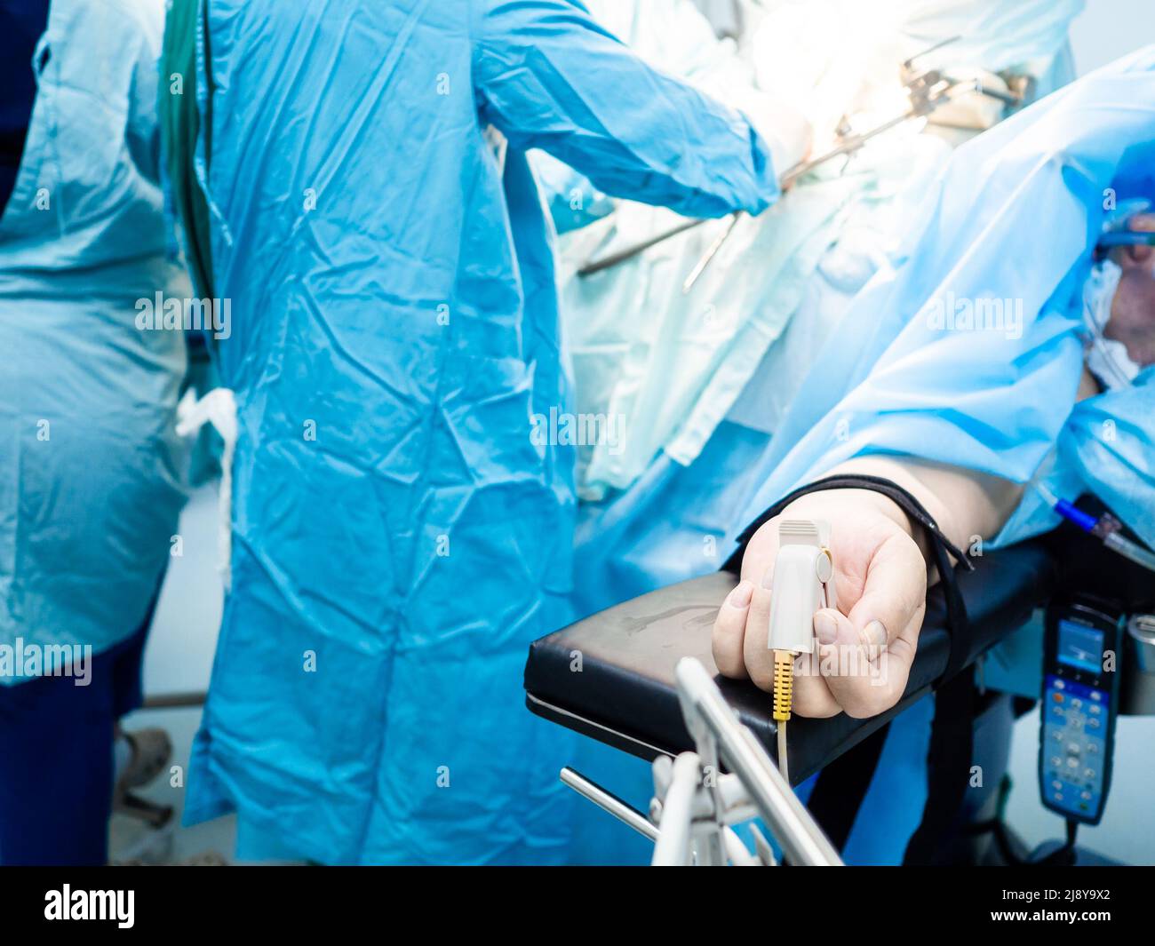 Close-up of a pulse oximeter on a patient's finger during surgery ...