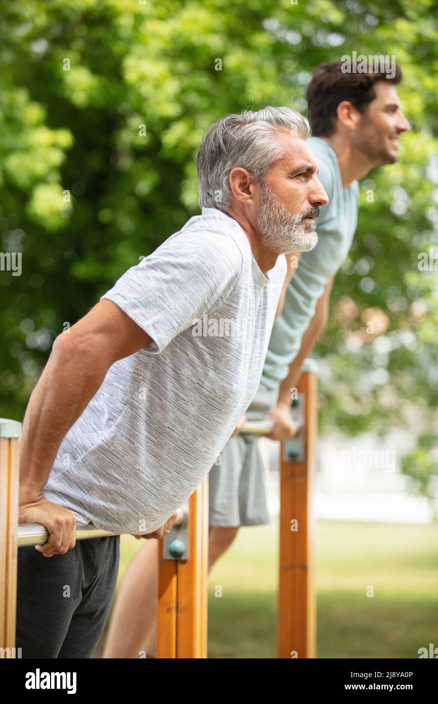 closeup of of men working out on horizontal bars Stock Photo - Alamy