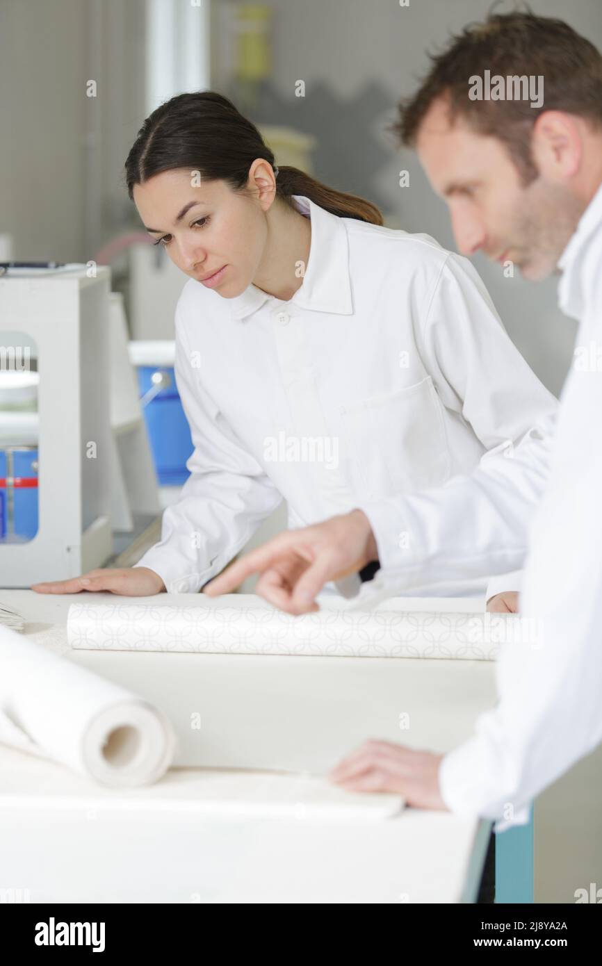 female apprentice learning how to wallpaper Stock Photo - Alamy