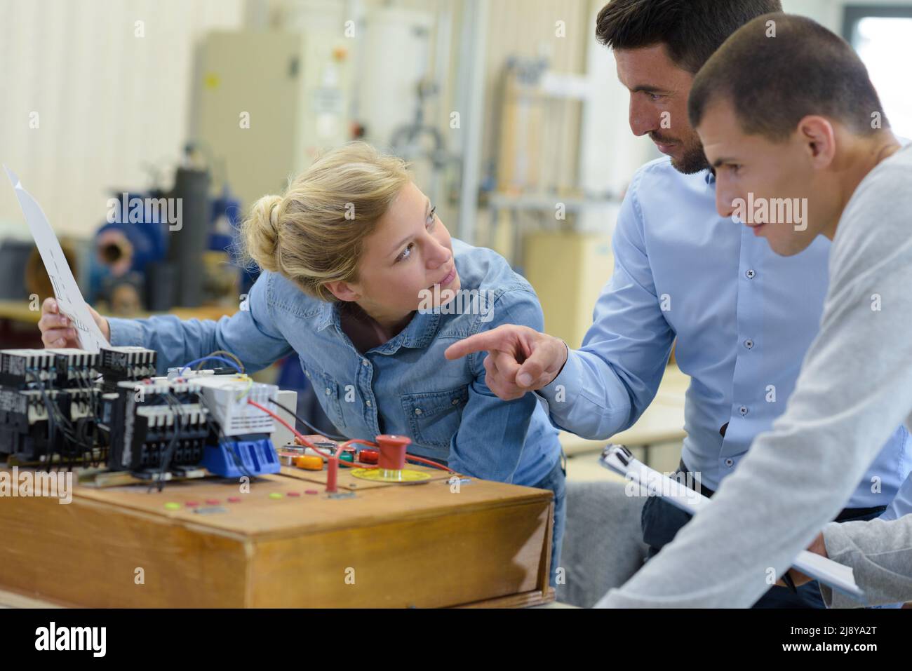 students discussing electronics board with tutor Stock Photo - Alamy