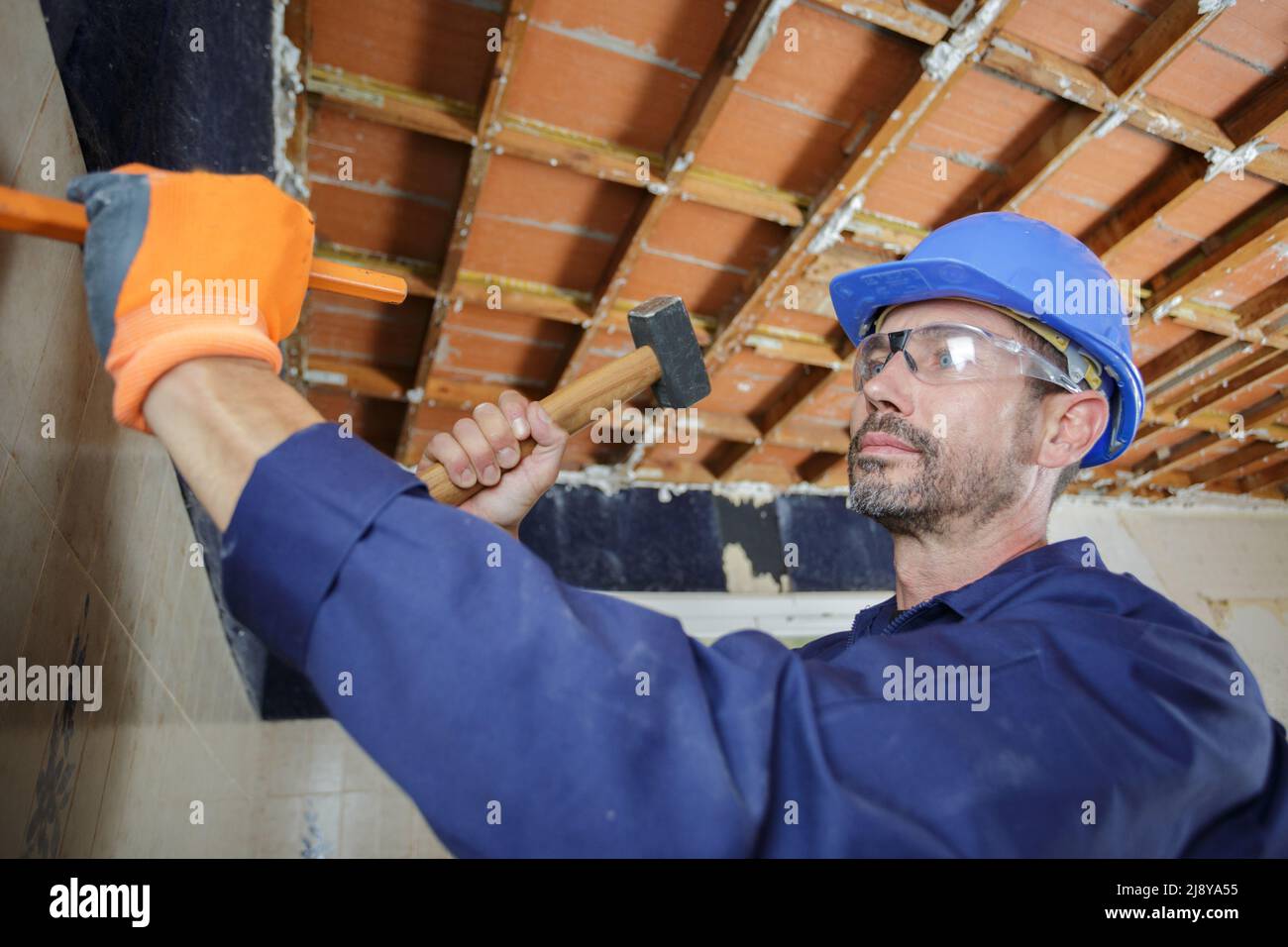 breaking wall with hammer and chisel Stock Photo - Alamy