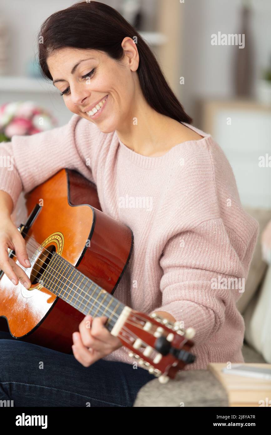 a beautiful woman smile while playing acoustic guitar Stock Photo - Alamy