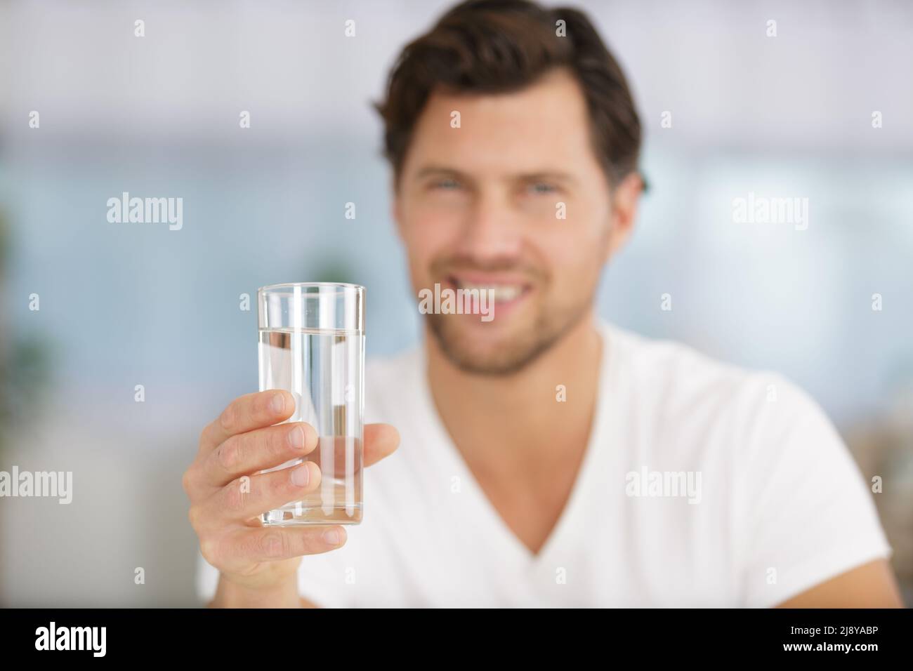 man holds out a glass of water Stock Photo - Alamy
