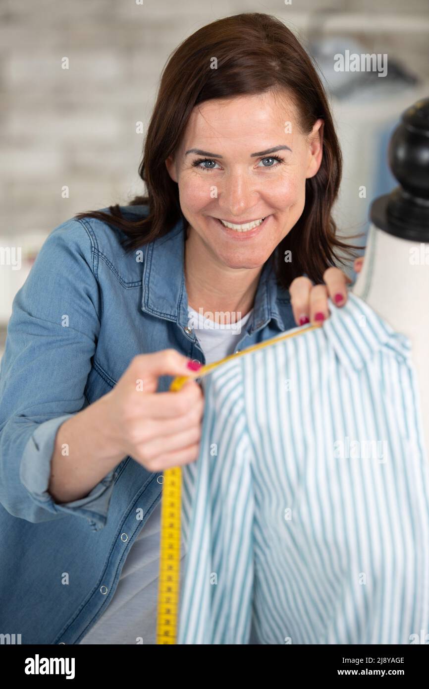 female fashion designer measuring mannequin Stock Photo - Alamy