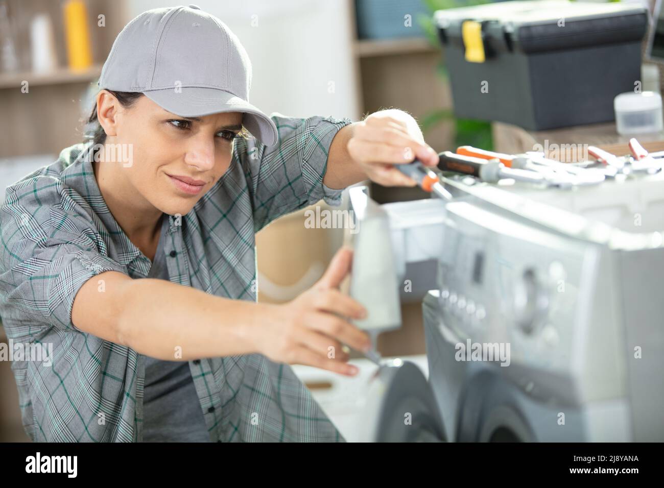 young woman technician repairing washing machine Stock Photo - Alamy