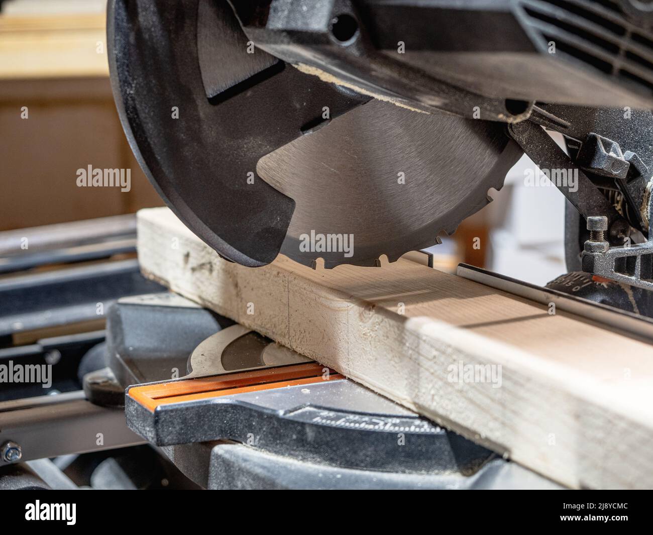 Close up of a Mitre saw in action chopping a plank of wood to a ...