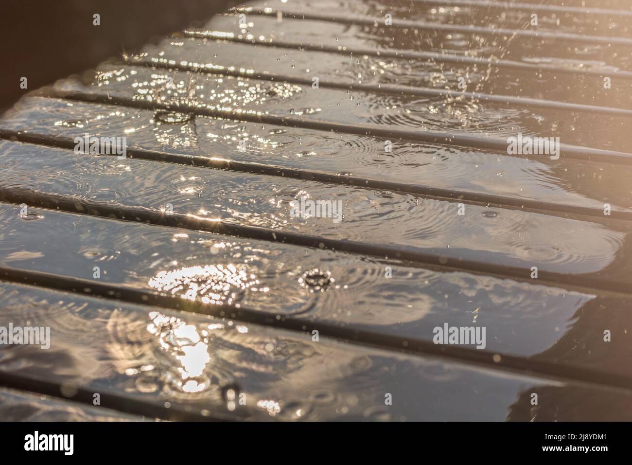 Rain patters on a garden table in the sunlight Stock Photo - Alamy