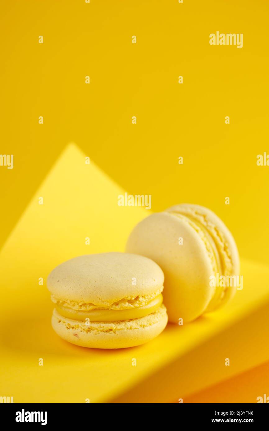 Lemon macaroons on a yellow background vertical Stock Photo - Alamy