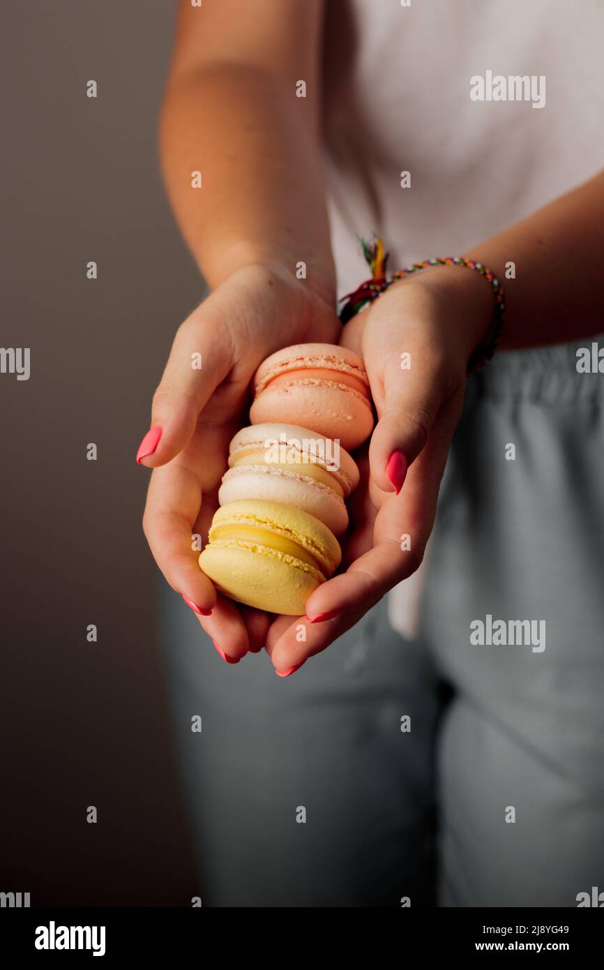 French macaroons in woman's hand Stock Photo - Alamy
