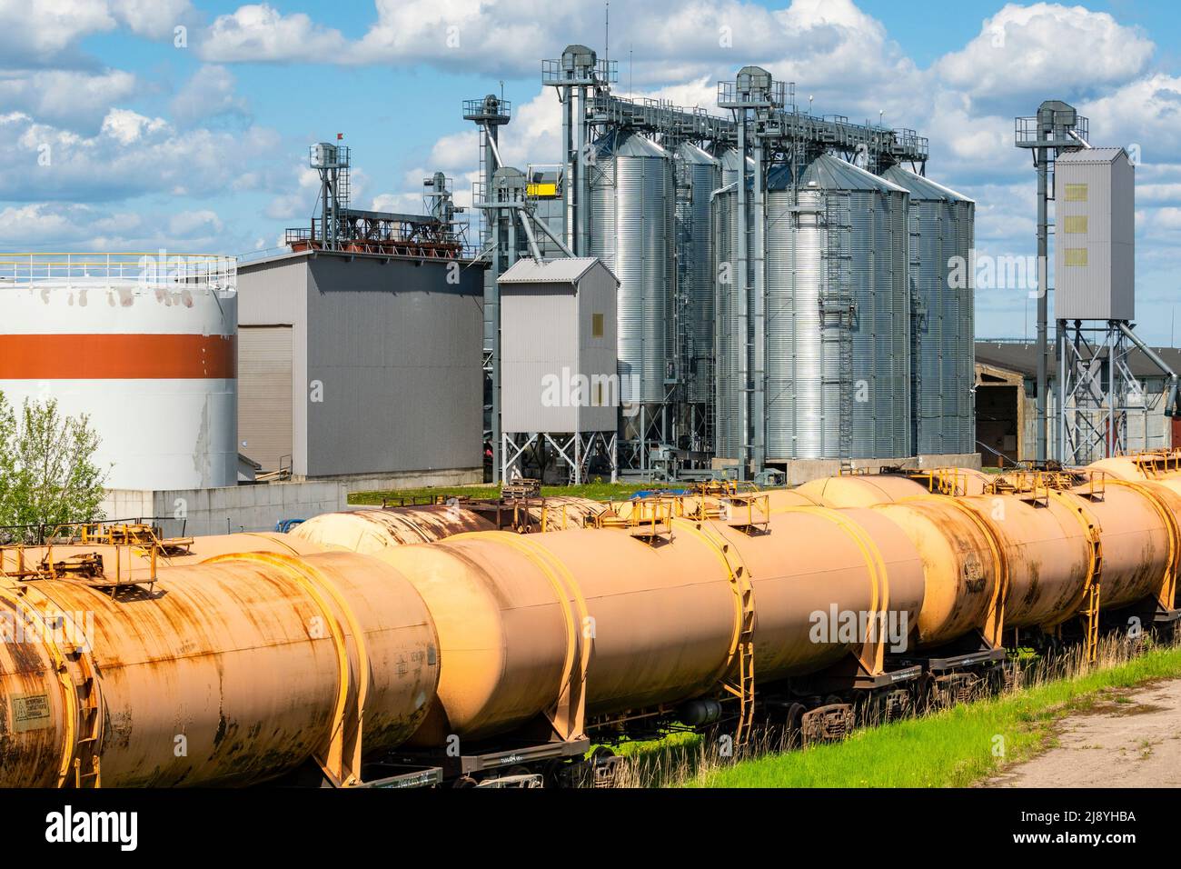 Grain silo, warehouse or depository next to railroad tracks with set of ...