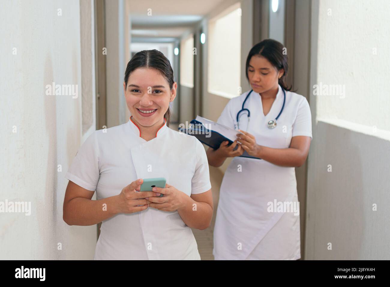 Hispanic Nurse Using A Mobile Phone In The Hospital Stock Photo - Alamy