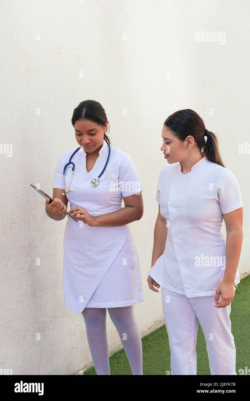 Latina nurse working on a tablet outside the hospital Stock Photo - Alamy