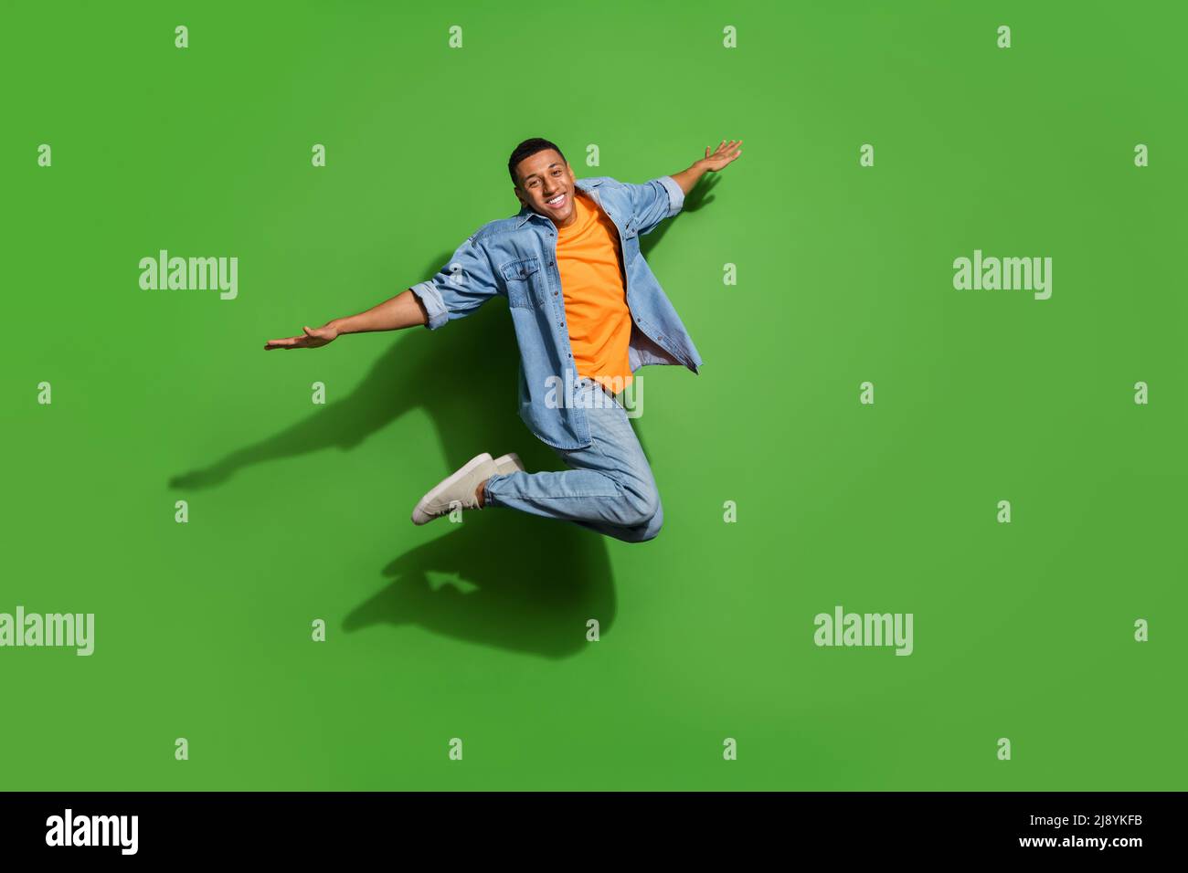 Full body photo of good mood man feeling free flying with spread arms ...