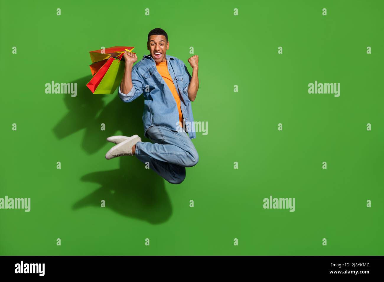 Full length photo of funny man addicted to shopping jumping up in ...