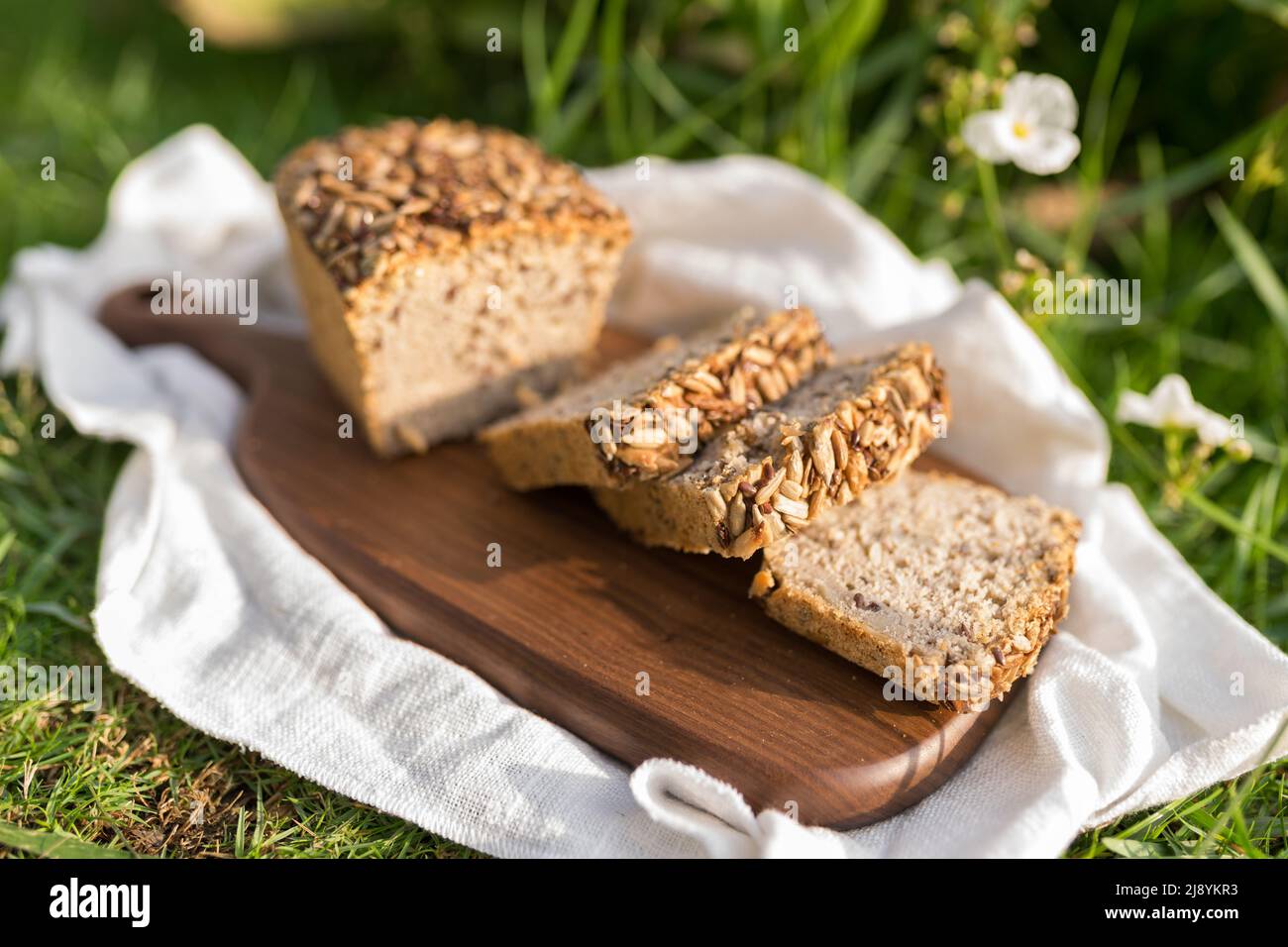 homemade grey bread with seeds on the wood board with the white cloth ...