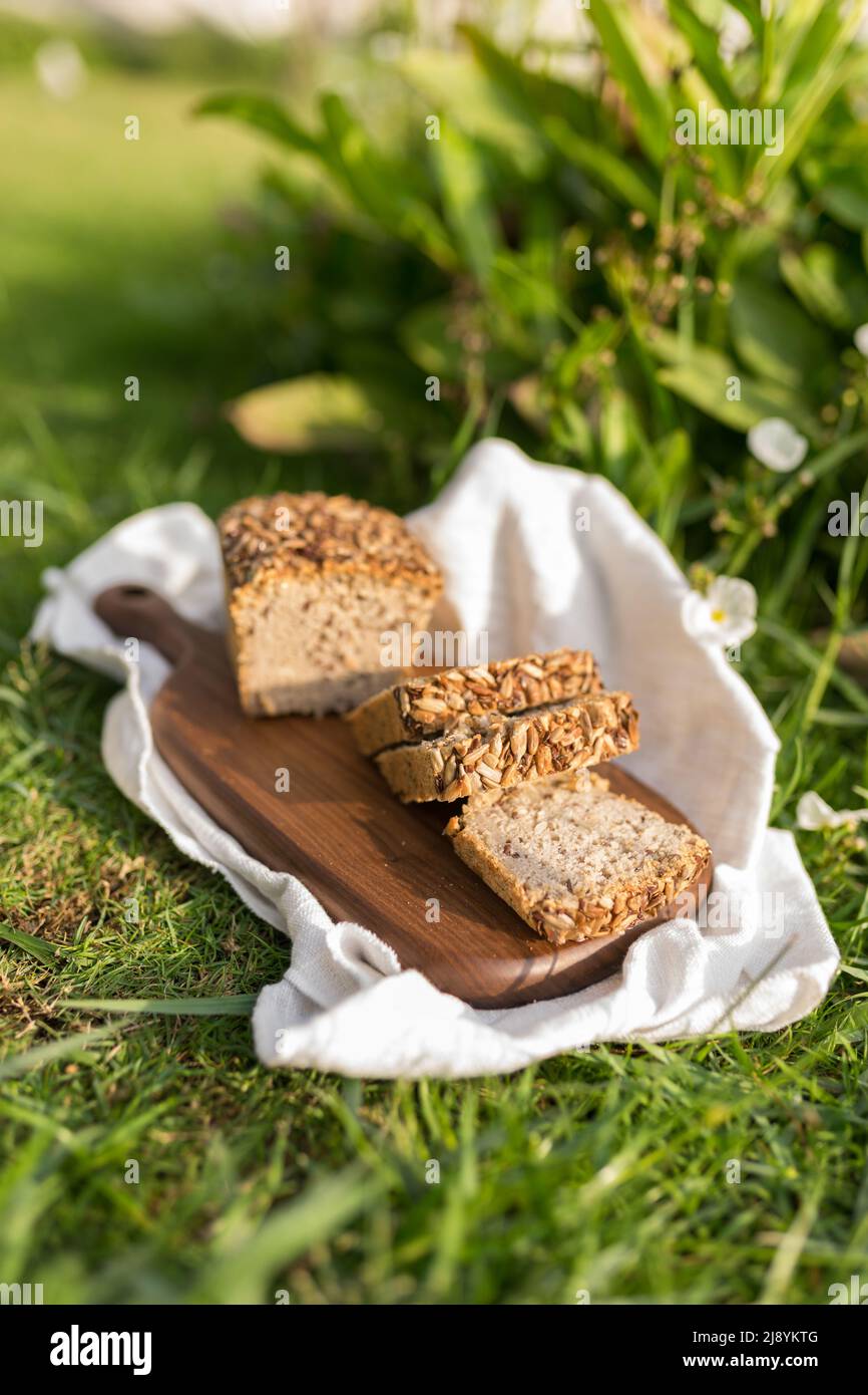 homemade grey bread with seeds on the wood board with the white cloth ...