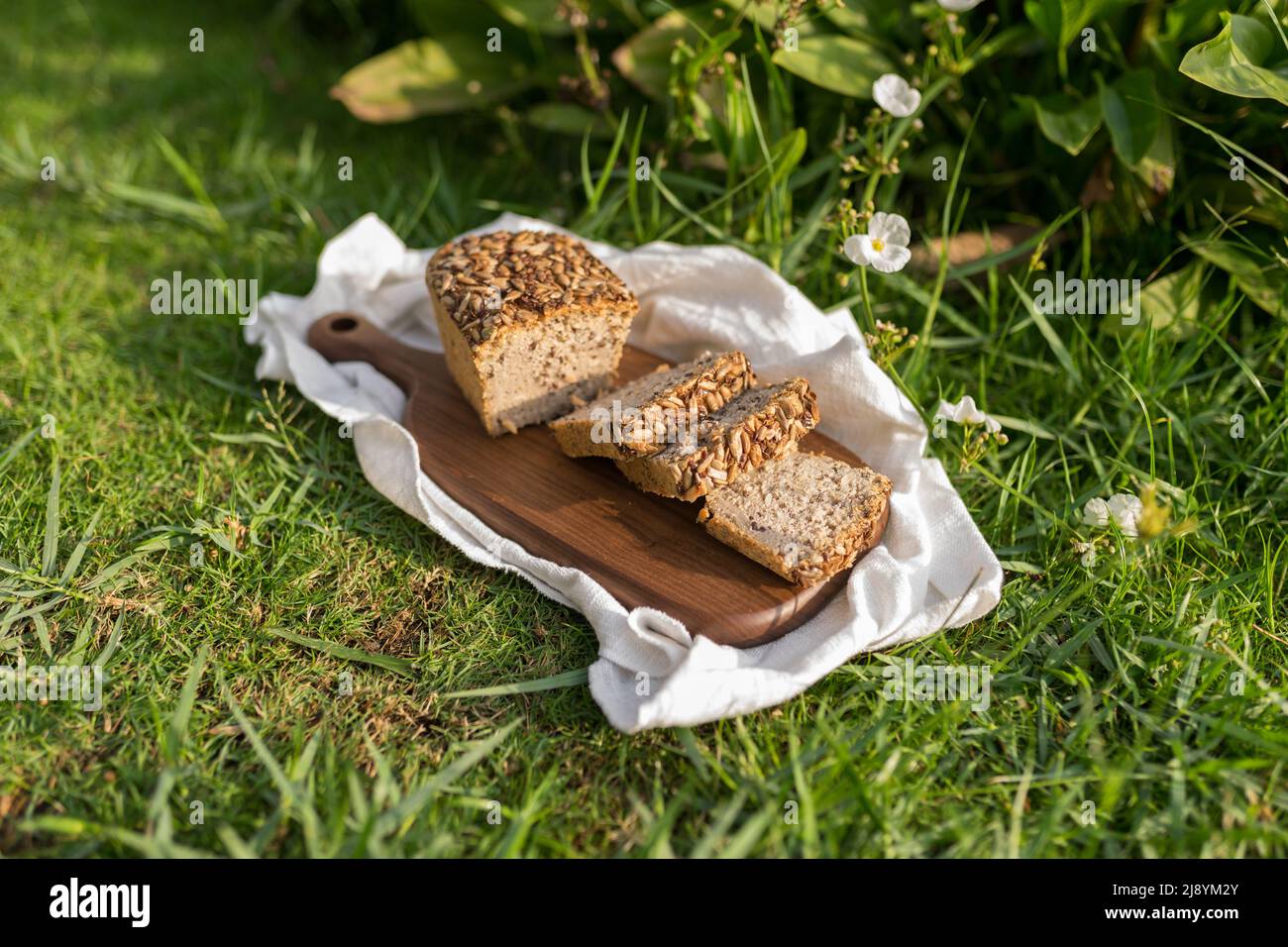 homemade grey bread with seeds on the wood board with the white cloth ...