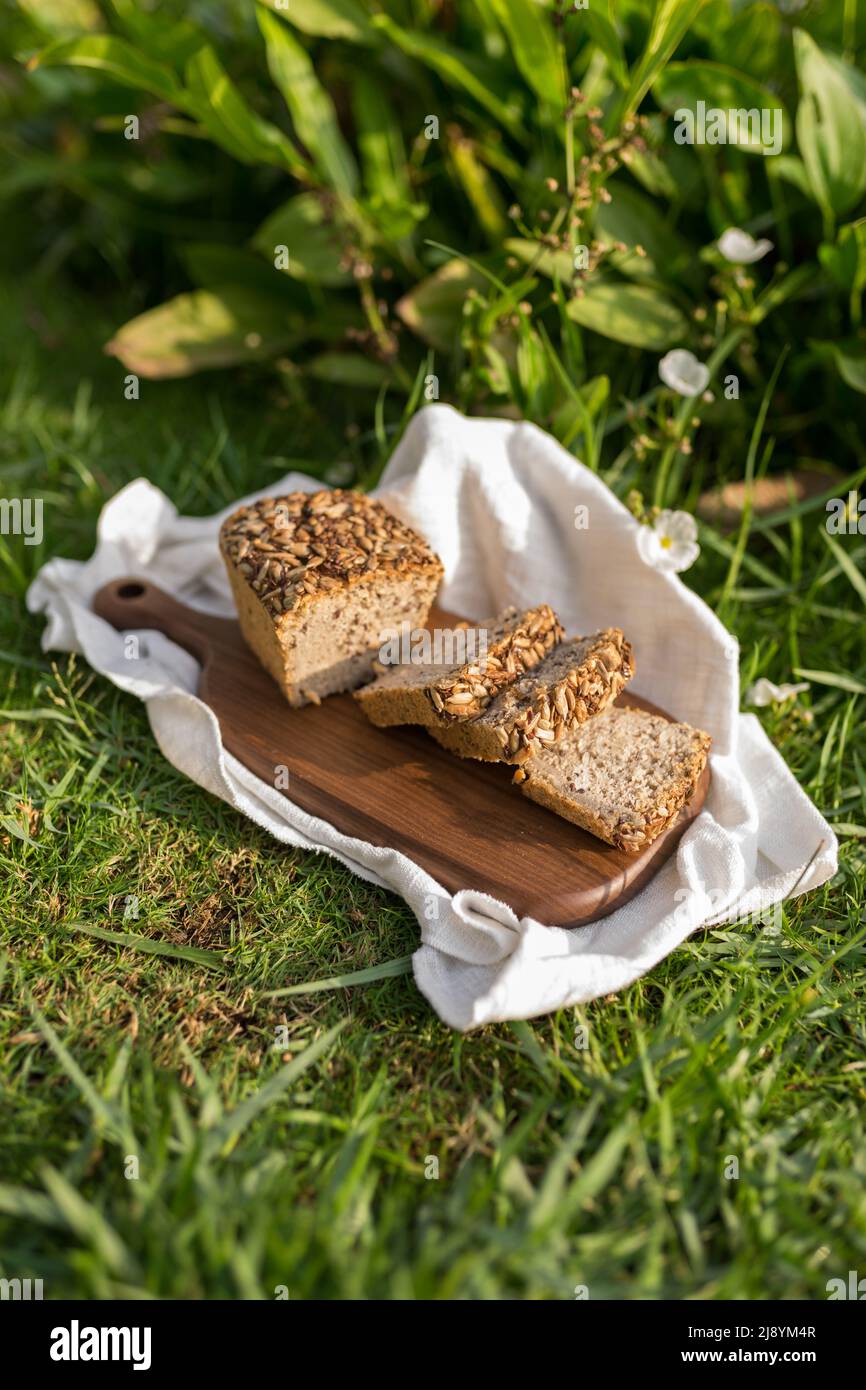 homemade grey bread with seeds on the wood board with the white cloth ...