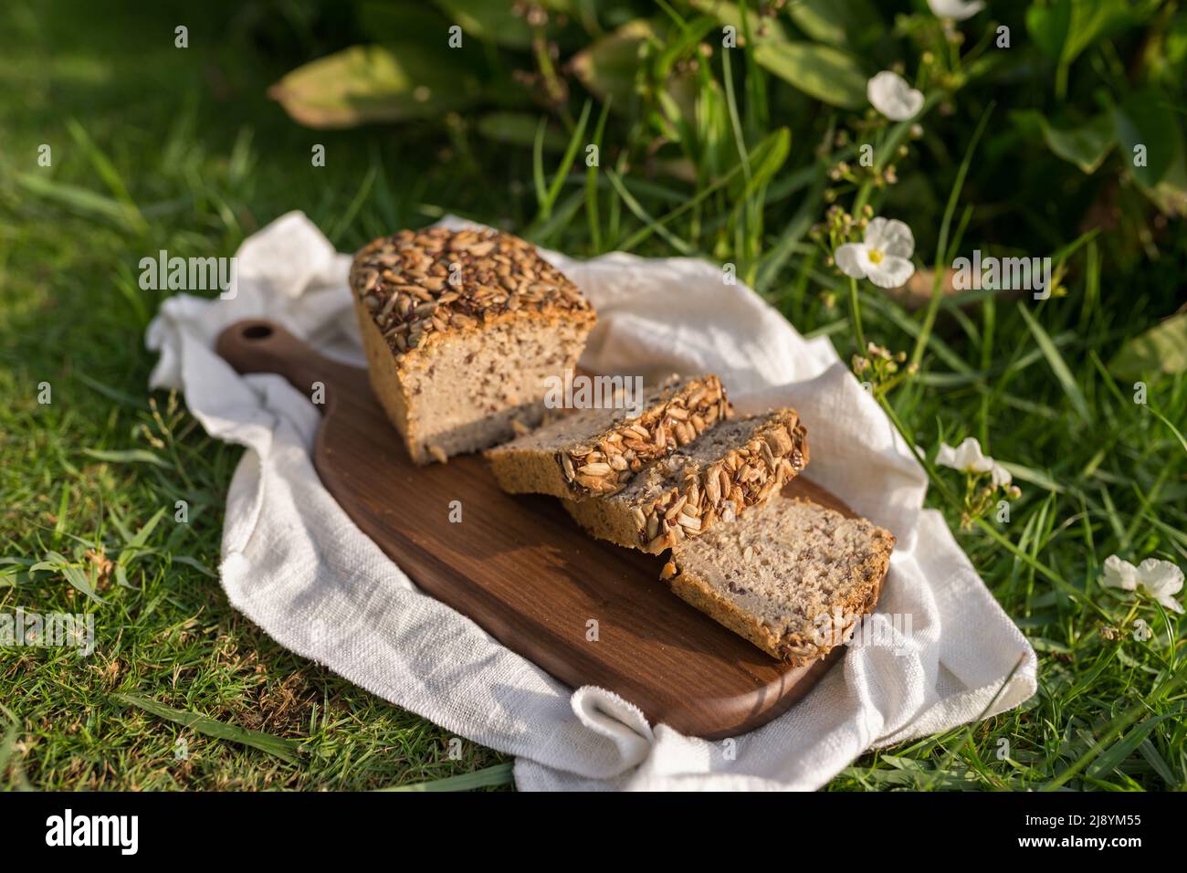 homemade grey bread with seeds on the wood board with the white cloth ...