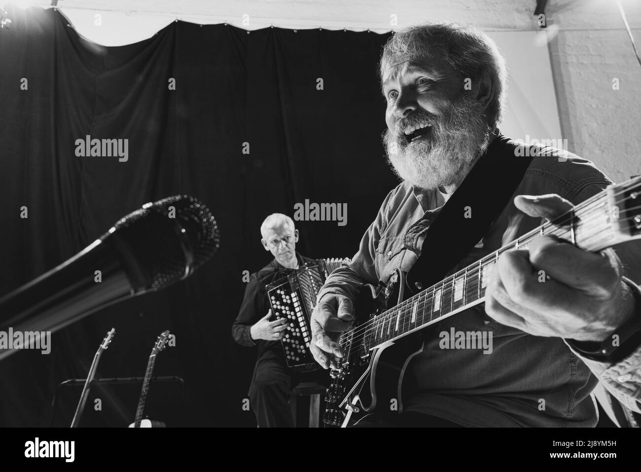 Two senior men, musicians playing electric guitar and accordion ...