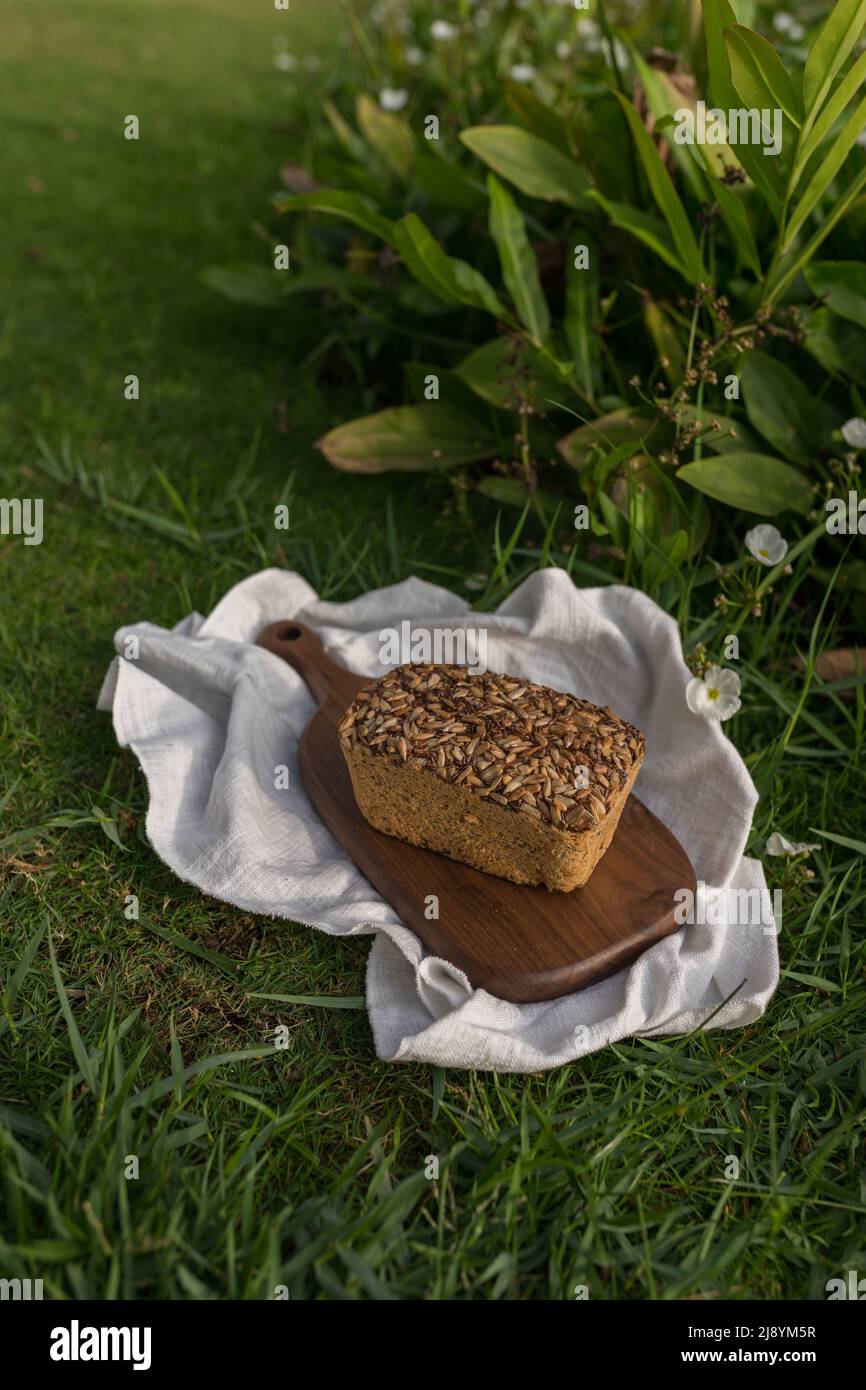 homemade grey bread with seeds on the wood board with the white cloth ...