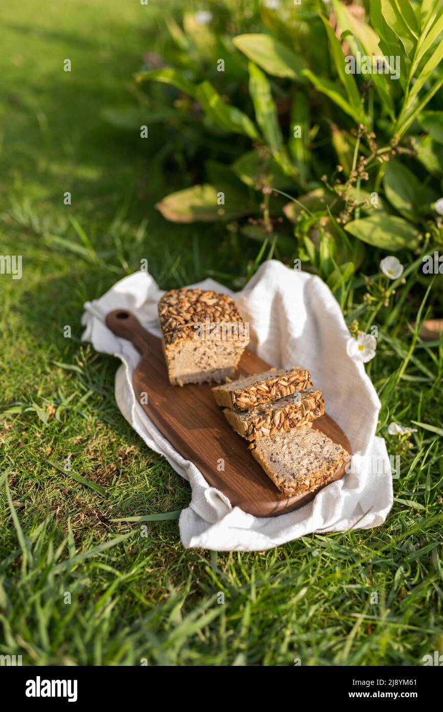 homemade grey bread with seeds on the wood board with the white cloth ...