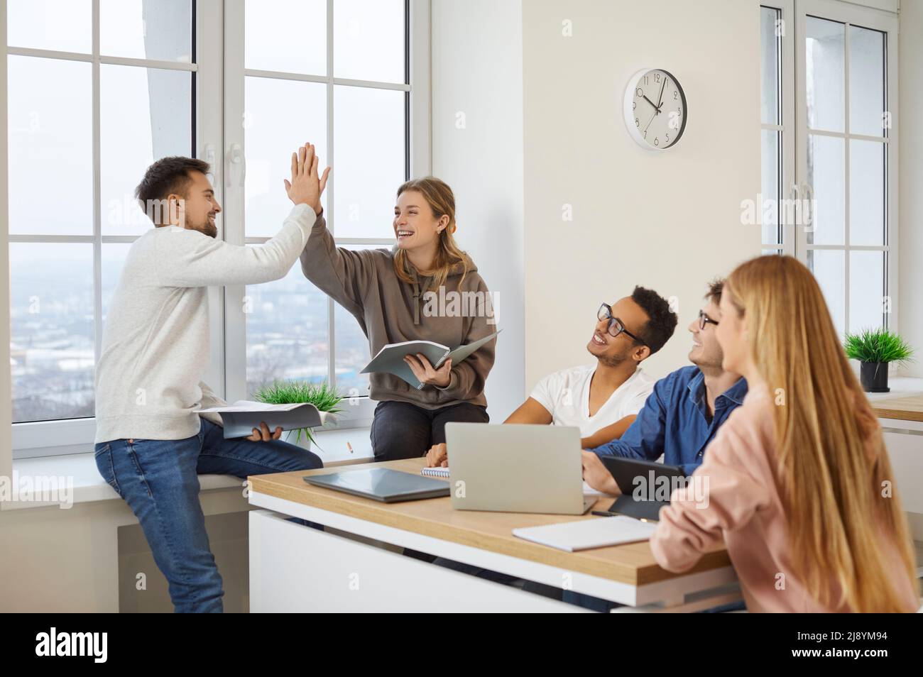 Happy multiethnic students give high five Stock Photo - Alamy