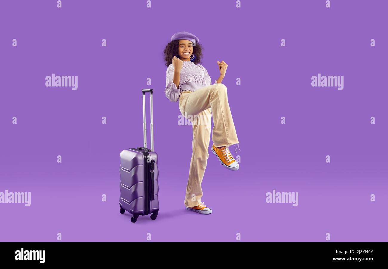 Happy cheerful girl with purple travel bag excited about going on ...