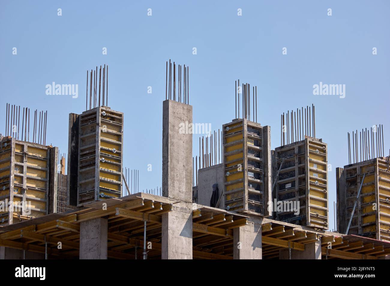 Unfinished cement building at a construction site. Blue sky background ...