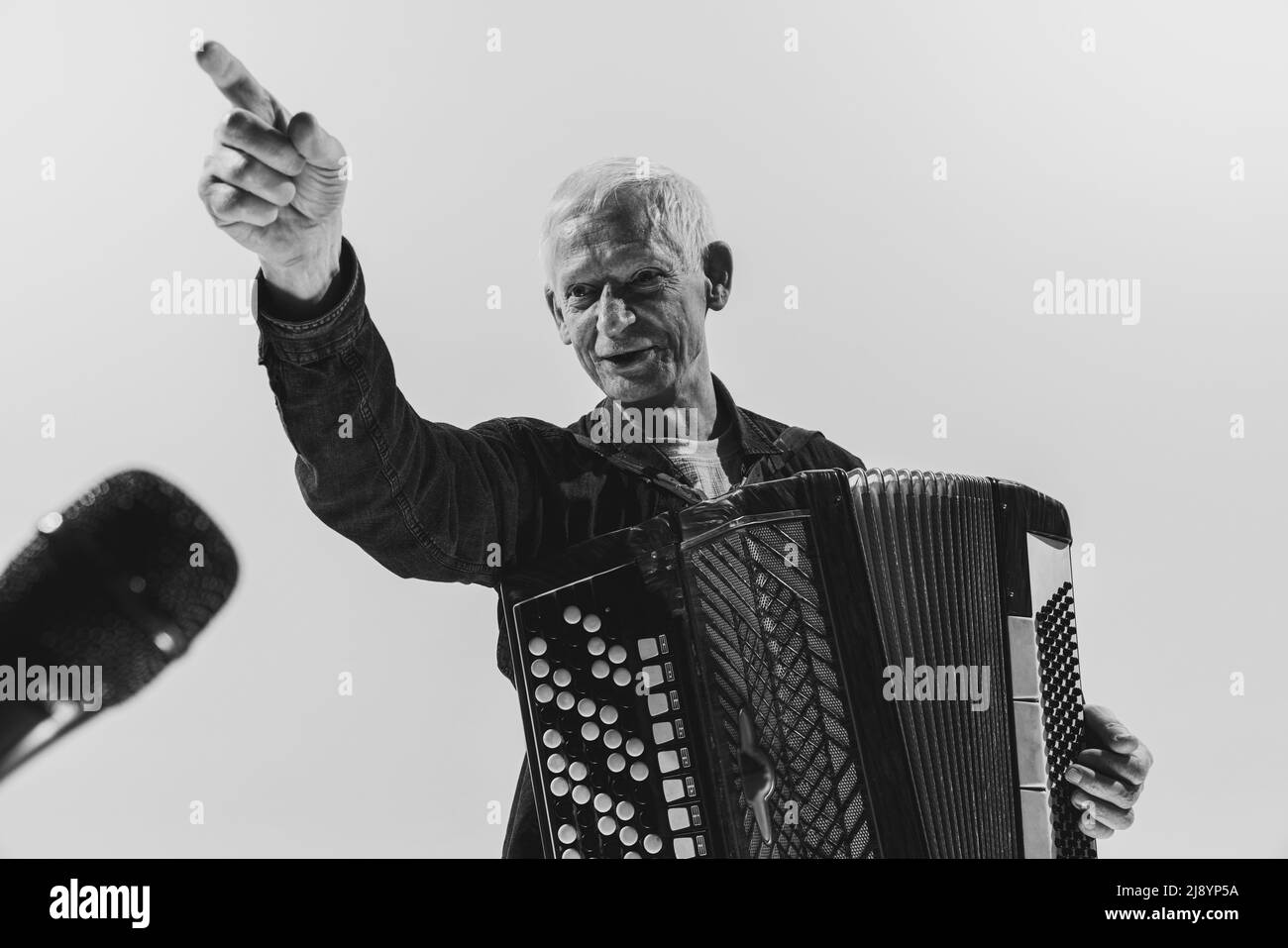 Monochrome portrait of seniot man, retro musician playing the accordion ...